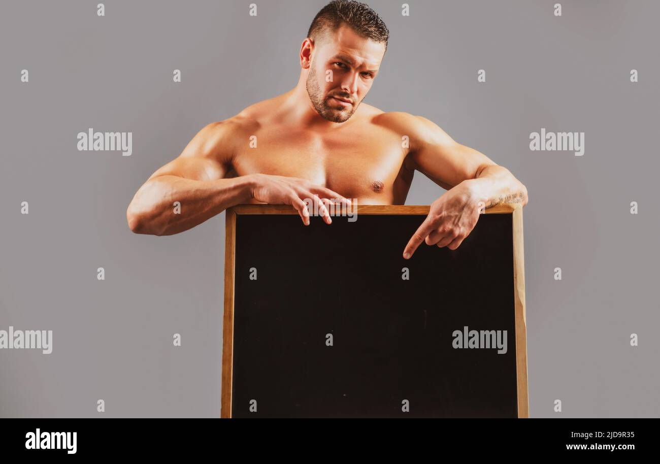 Handsome bodybuilder man with sign advertising board. Strong muscular ...