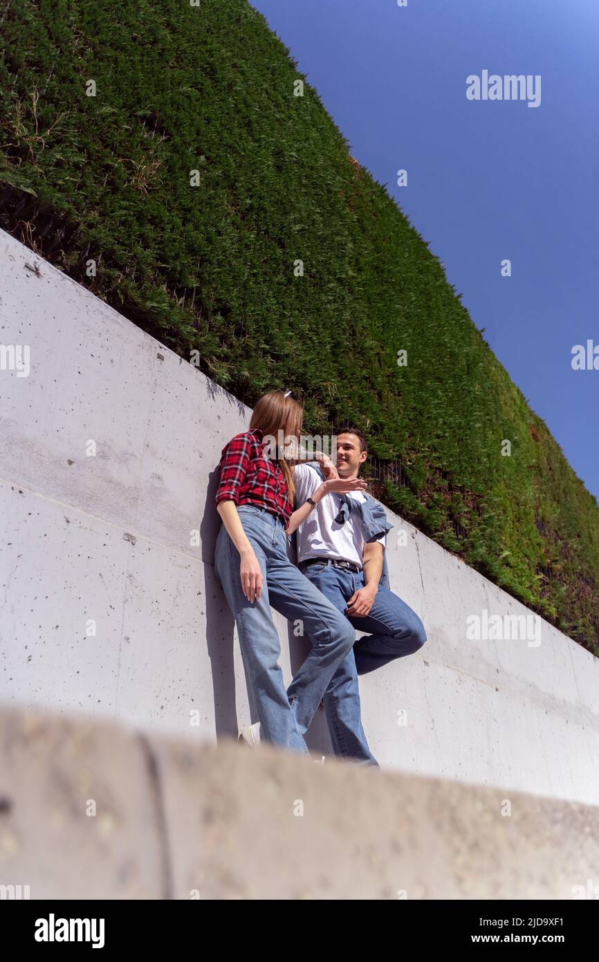 Cute couple hanging out while leaning on the silver wall Stock Photo ...