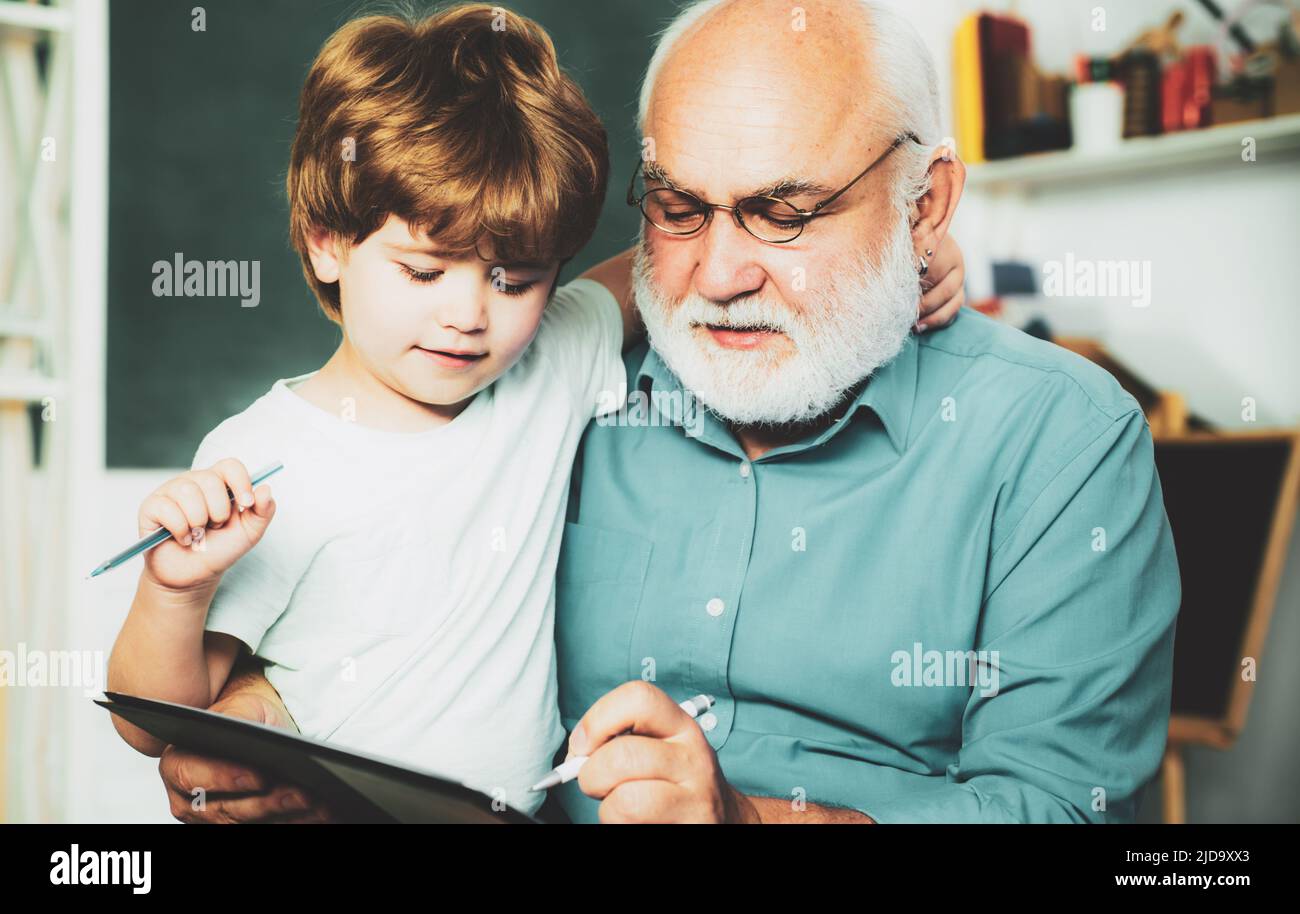 Grandfather with grandson learning together. Friendly child boy with ...