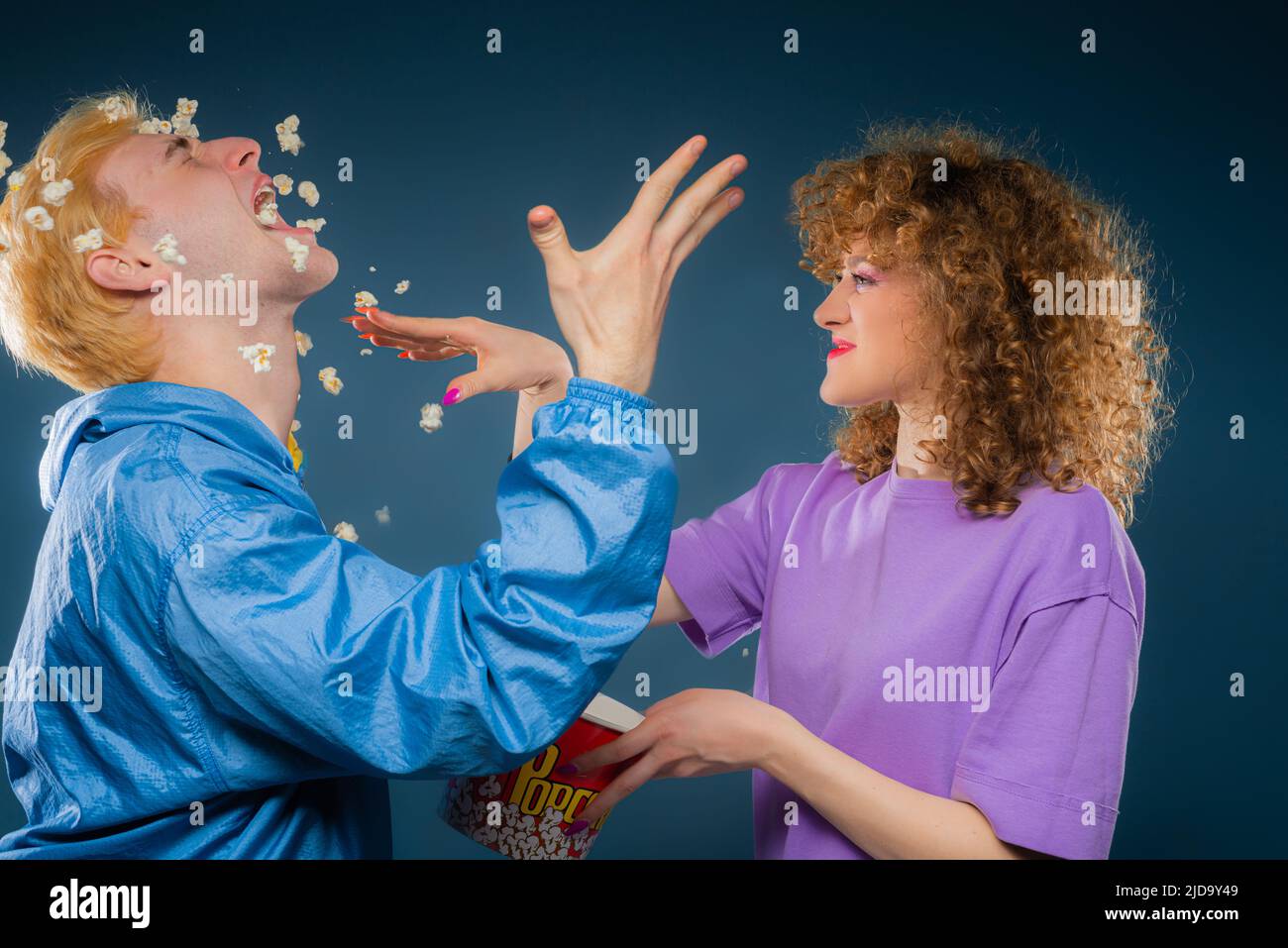 Cute and crazy couple is giving popcorn to each other by throwing Stock ...