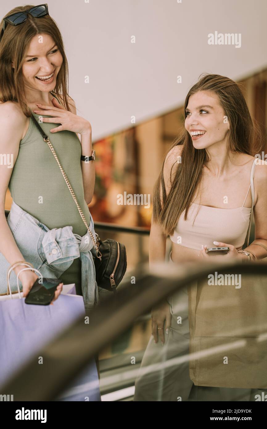 Close up of two cute girls going up on the escalator at the mall Stock ...