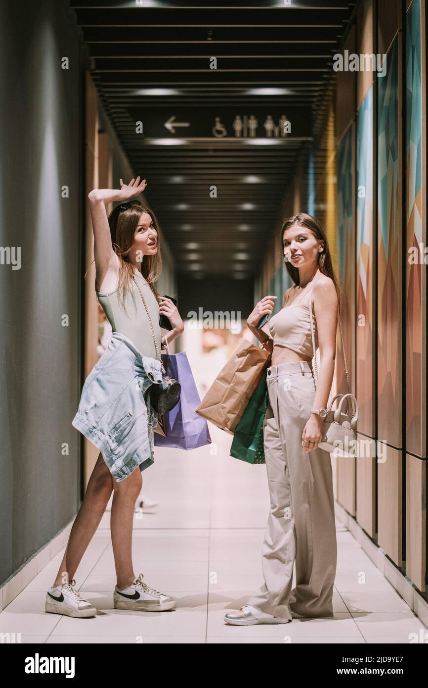Two pretty shopping girls standing in the hallway in the mall Stock ...