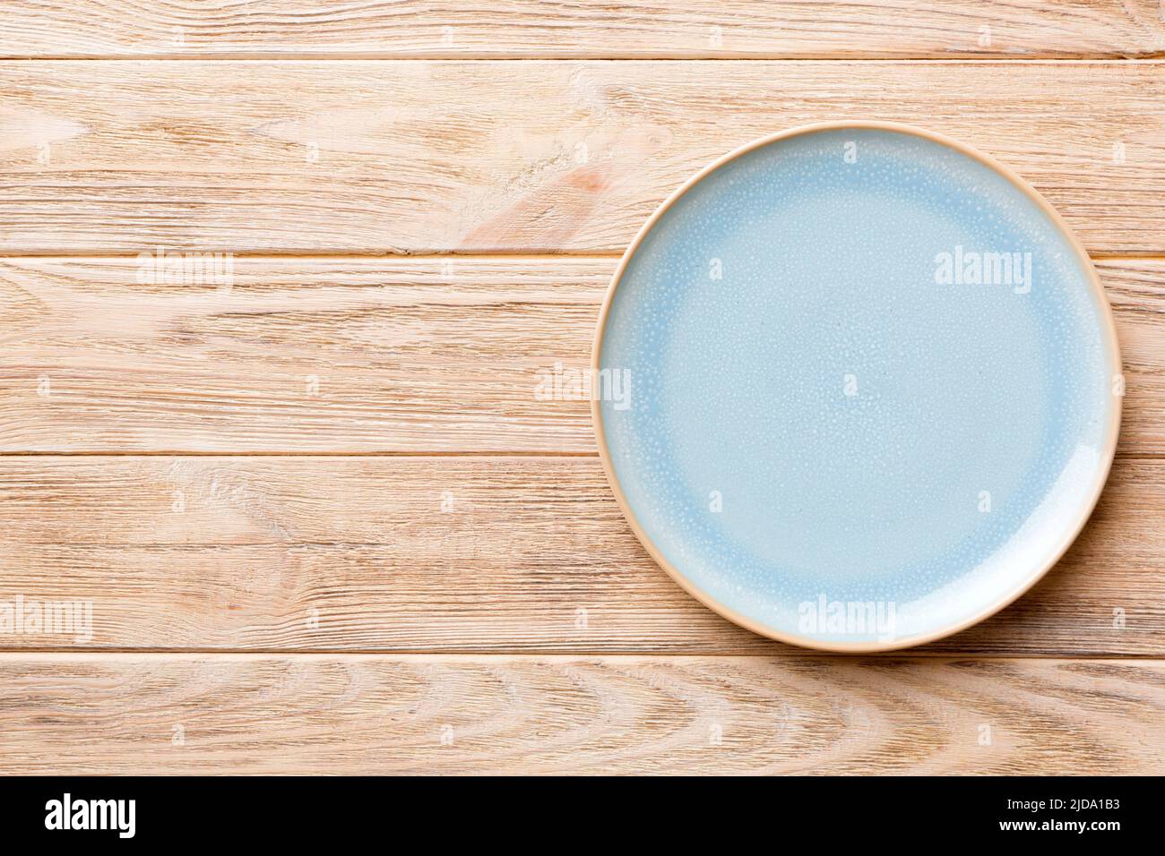 Top view of empty blue plate on wooden background. Empty space for your ...