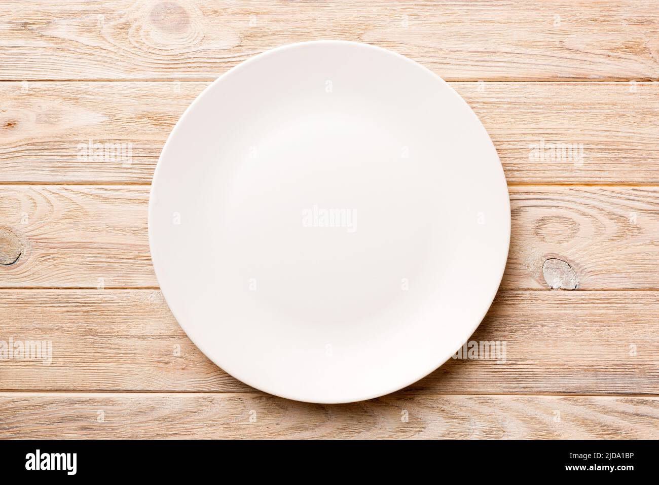 Top view of empty light plate on wooden background. Empty space for ...