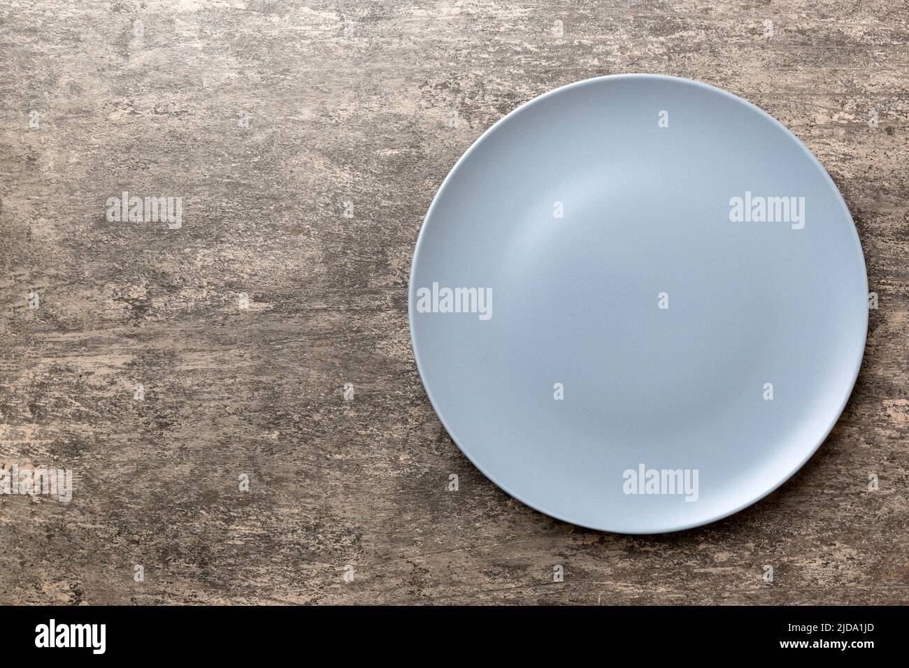 Top view of empty light plate on wooden background. Empty space for ...