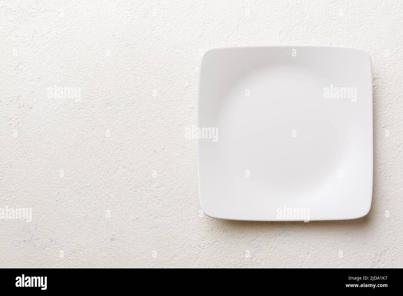 Top view of empty square plate on cement background. Empty space for ...