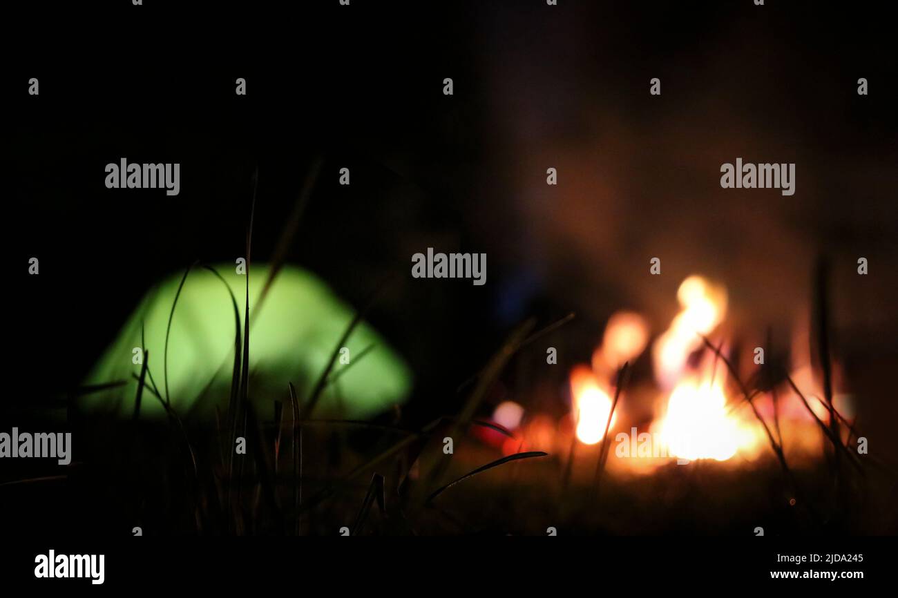 Blurred background - tents and fire in the night. The concept of fire ...
