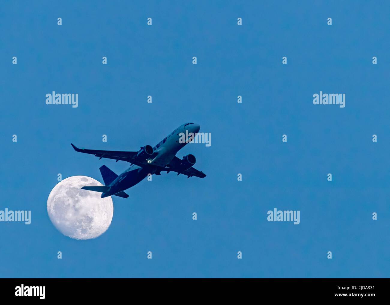 A moon coming out of plane in a night sky Stock Photo - Alamy