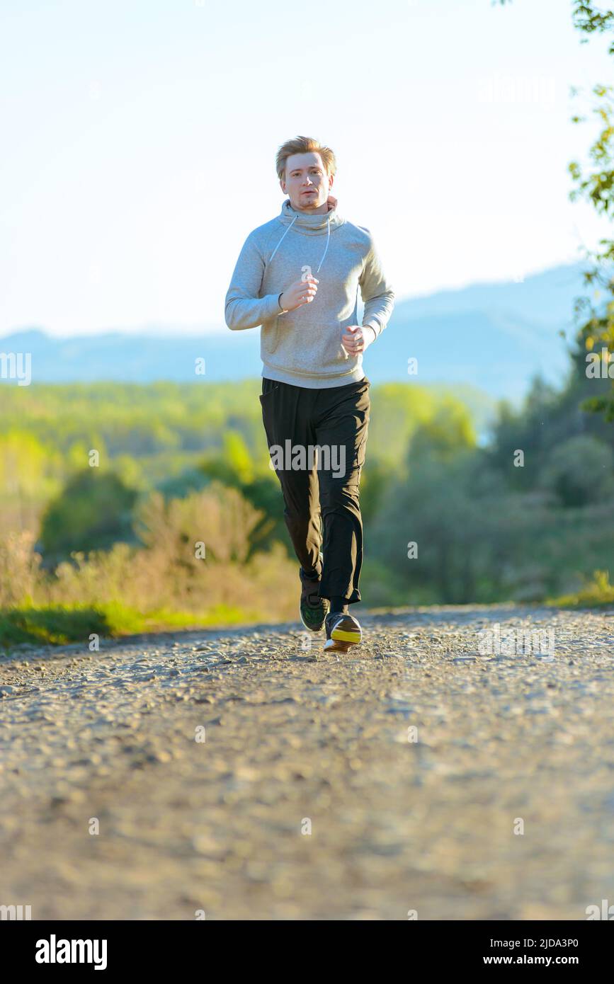 Running man jogging in rural nature at beautiful summer day. Sport ...