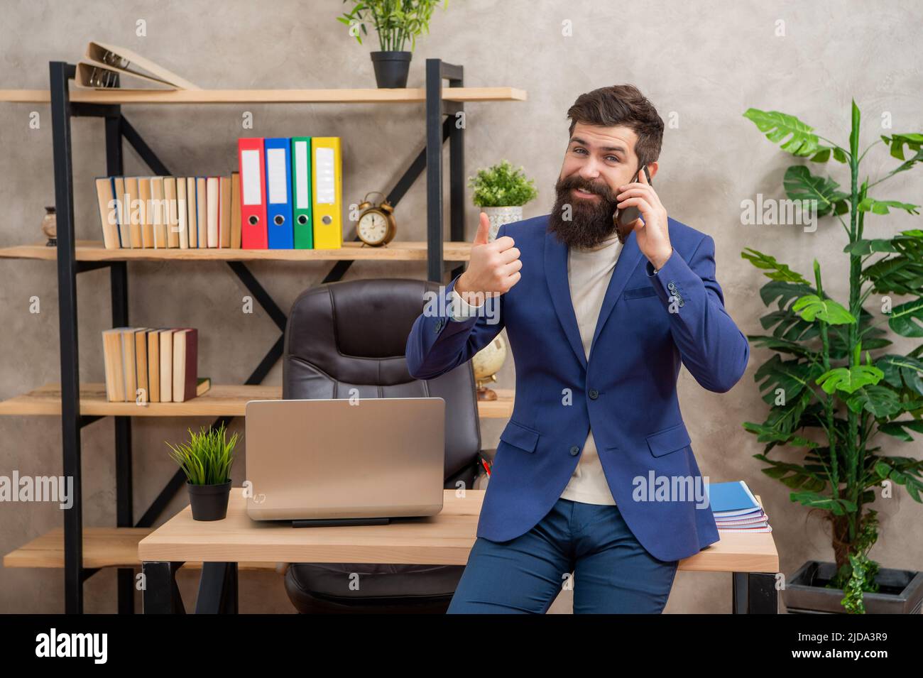 Giving thumbs up. Happy manager talking on phone show thumb gesture ...