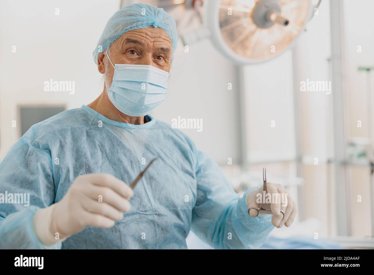 Professional doctor surgeon holding scalpel and forceps in operation ...