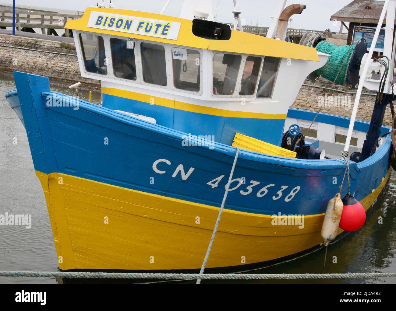 A brightly coloured fishing boat in the port of Grandcamp-Maisy ...