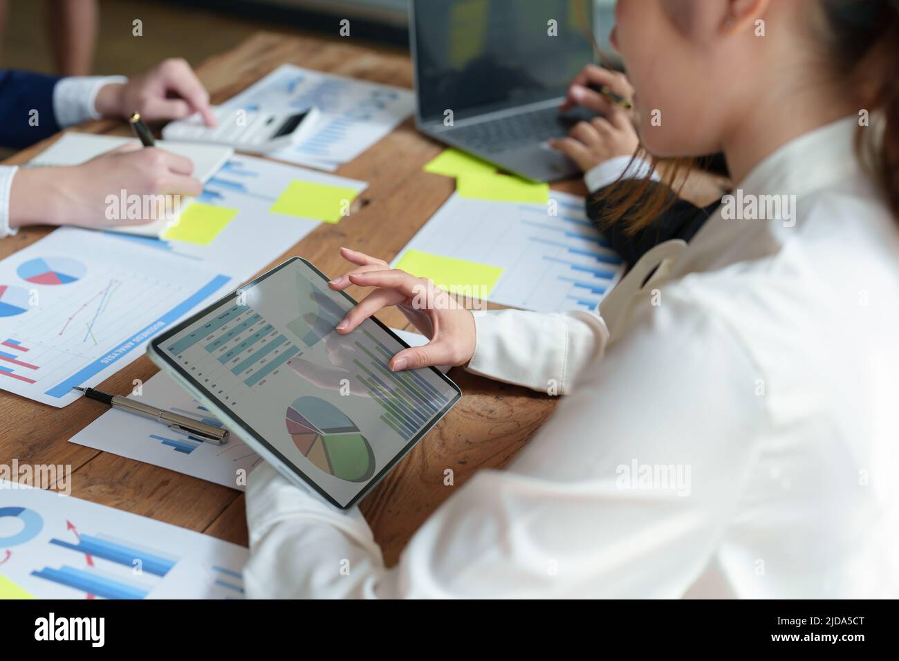 Businesswoman using a tablet to discuss marketing strategy summaries ...