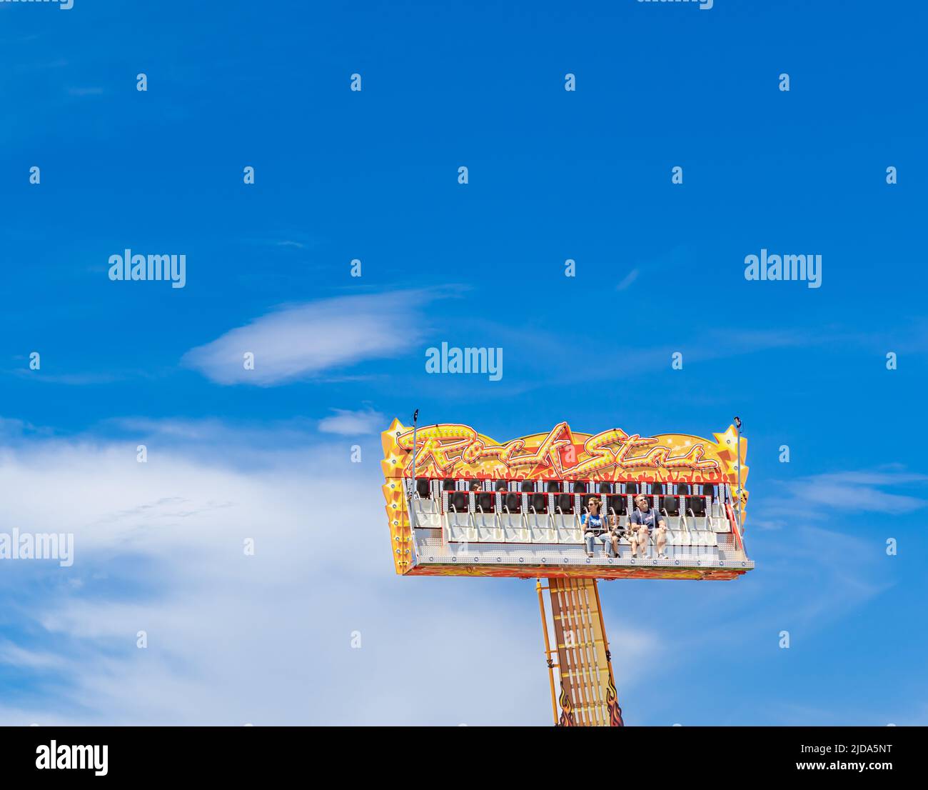 Family of three on a carnival ride called teh Rock Star Stock Photo - Alamy
