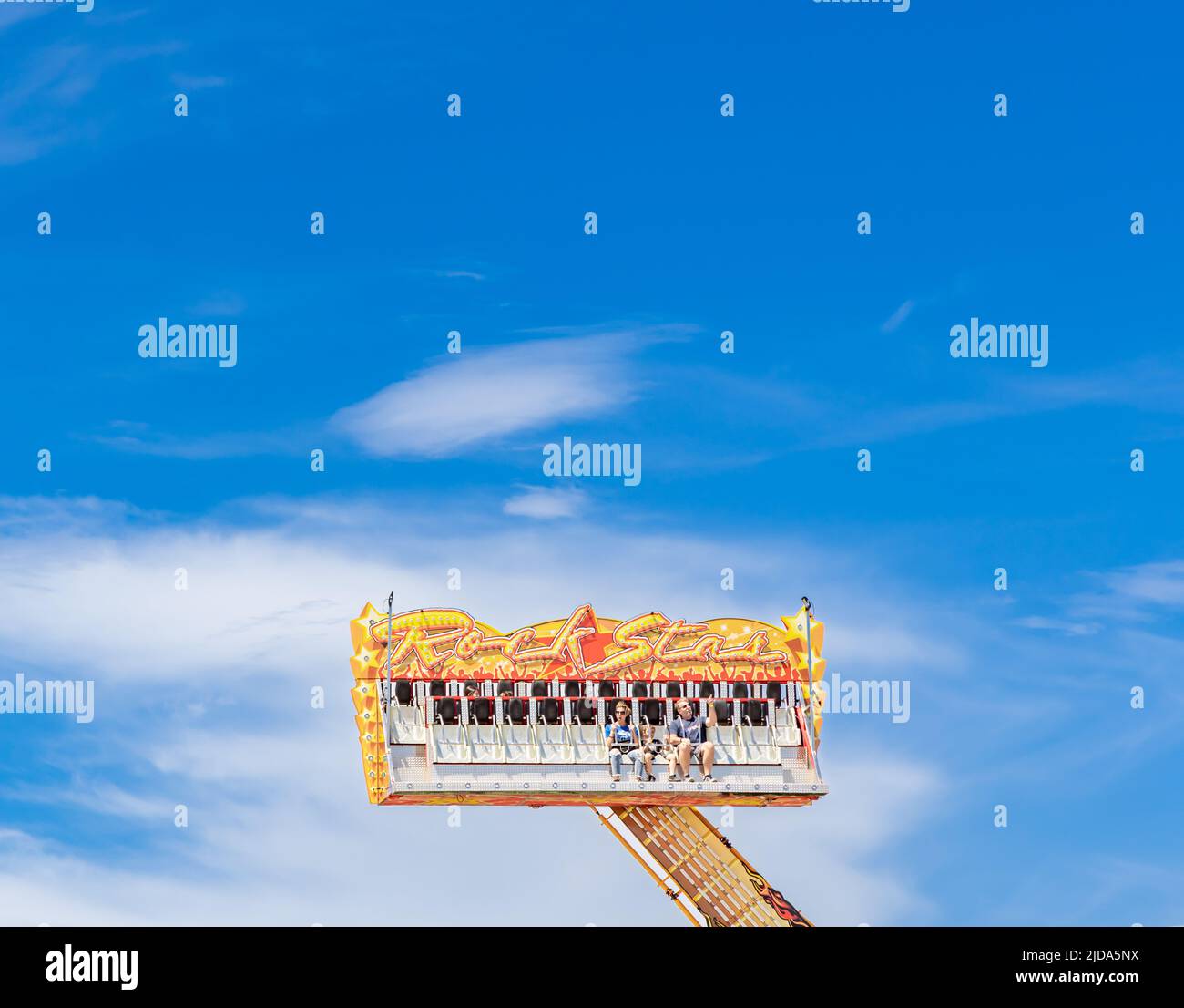 Family of three on a carnival ride called teh Rock Star Stock Photo - Alamy