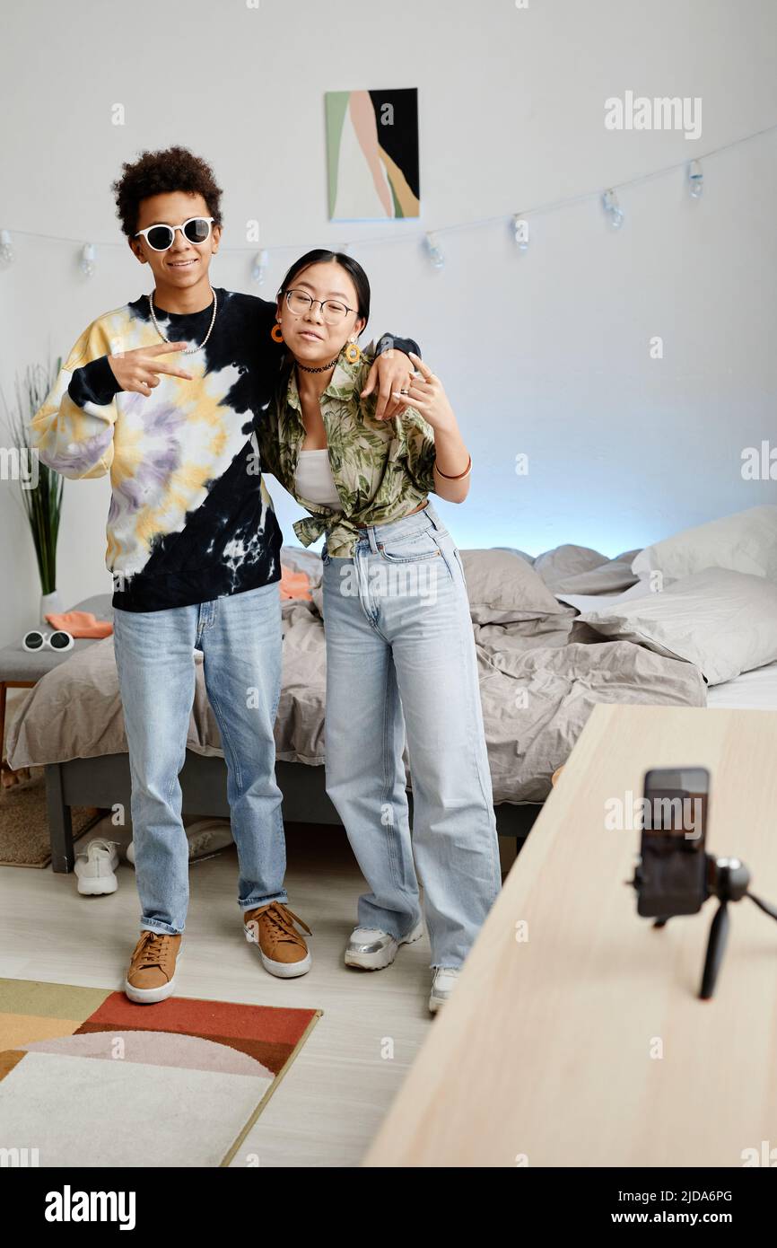 Full length portrait of two gen Z teenagers filming video for social ...