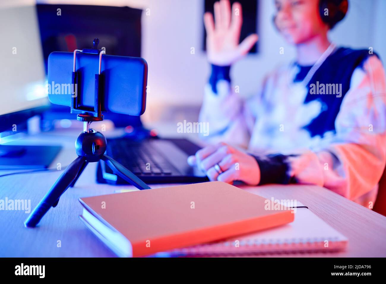 Closeup of teenage boy playing video game and streaming live in blue ...