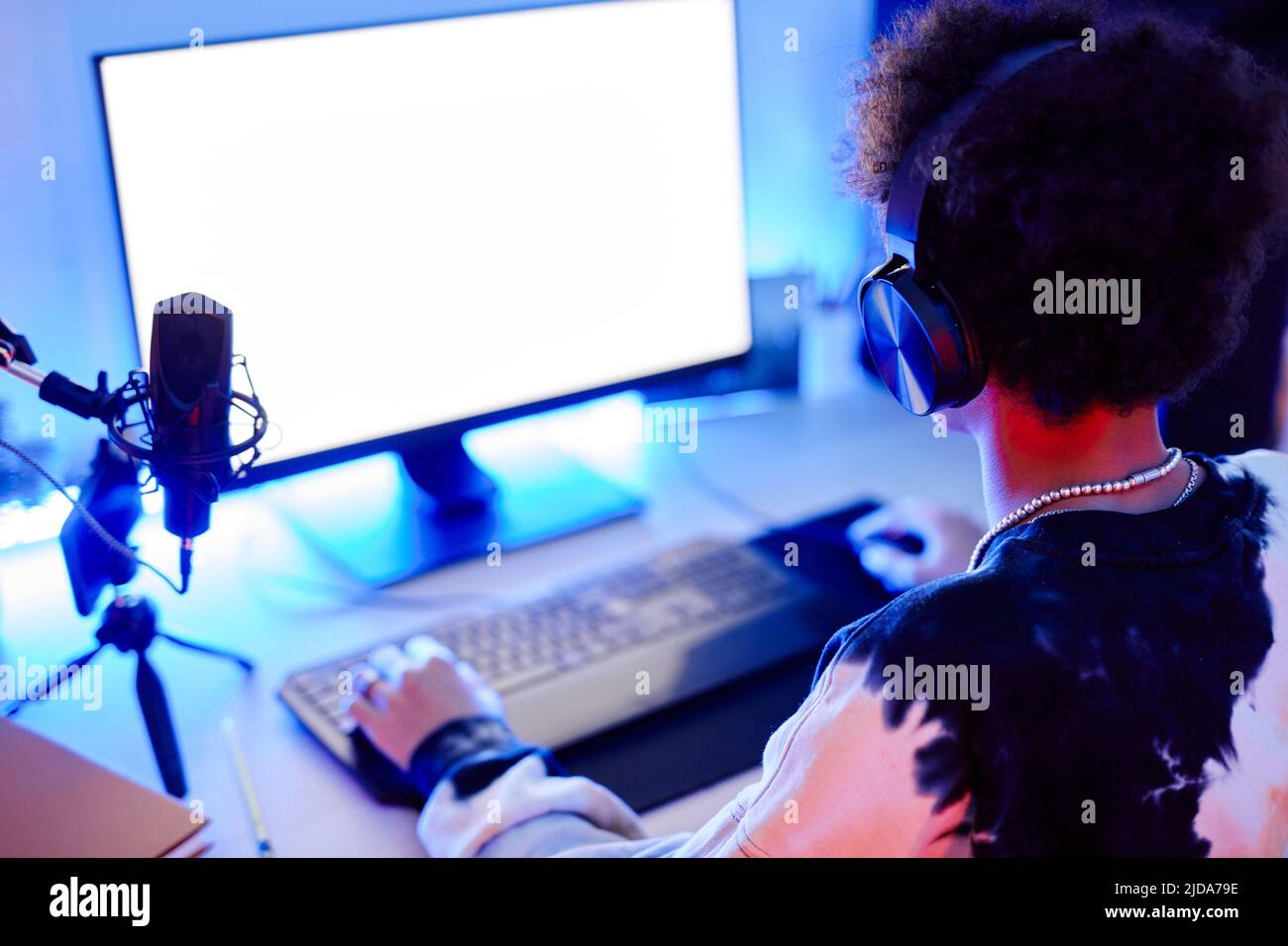 Closeup of teenage boy playing video game and streaming live in blue ...