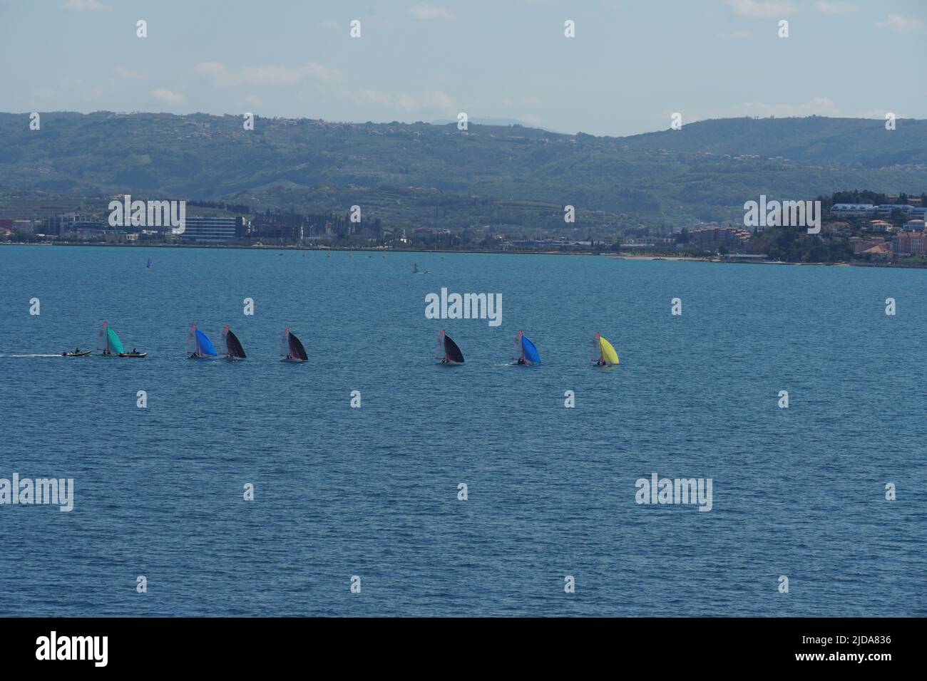 Small sailing boats with different colors sails passing through bay in ...