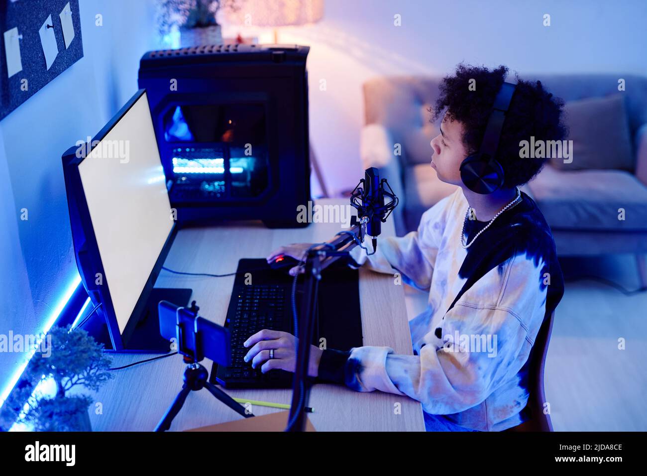 High angle portrait of black teenage boy playing video games at night ...