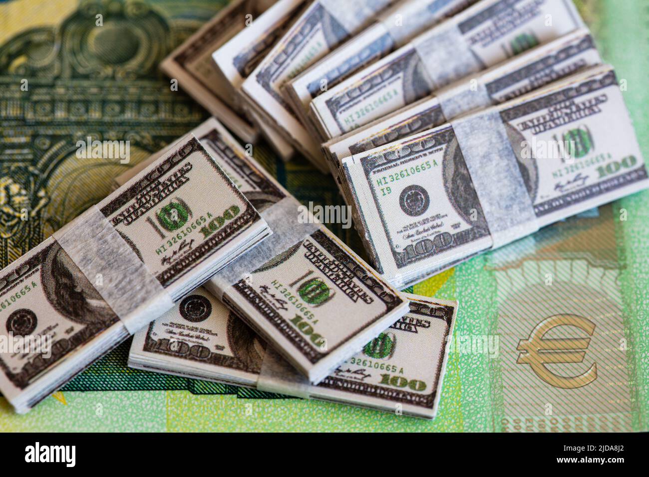 bundles of miniature 100 dollar banknotes on 100 euro banknote ...