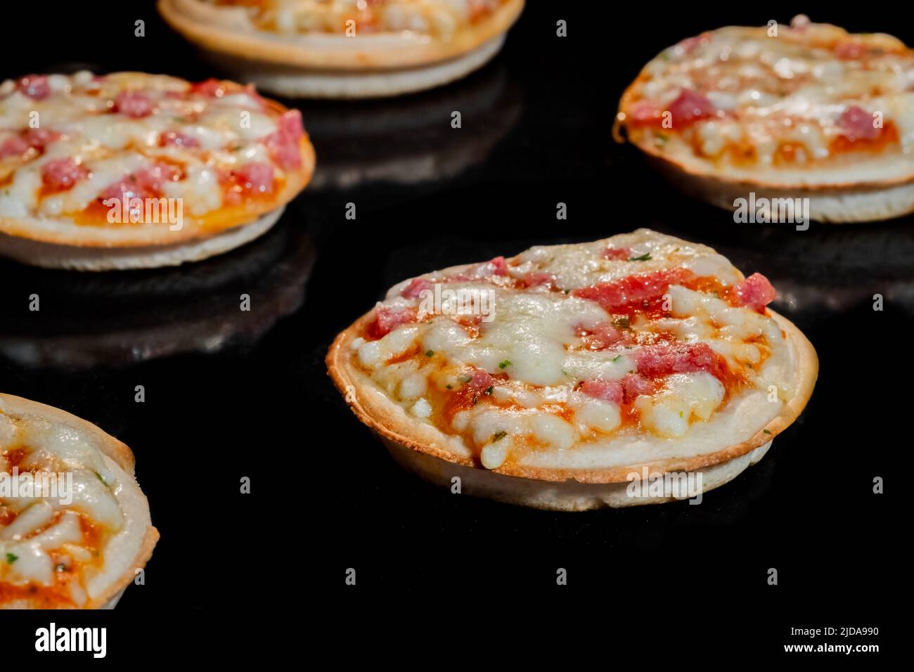 Homemade mini pizzas baking on tray in electric oven, black background Stock Photo - Alamy
