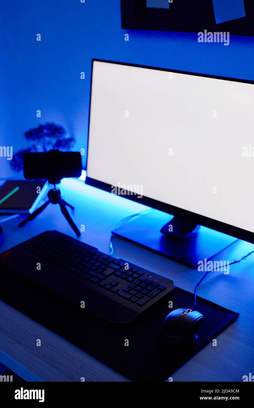 Vertical background image of gaming setup PC on desk lit with blue neon ...