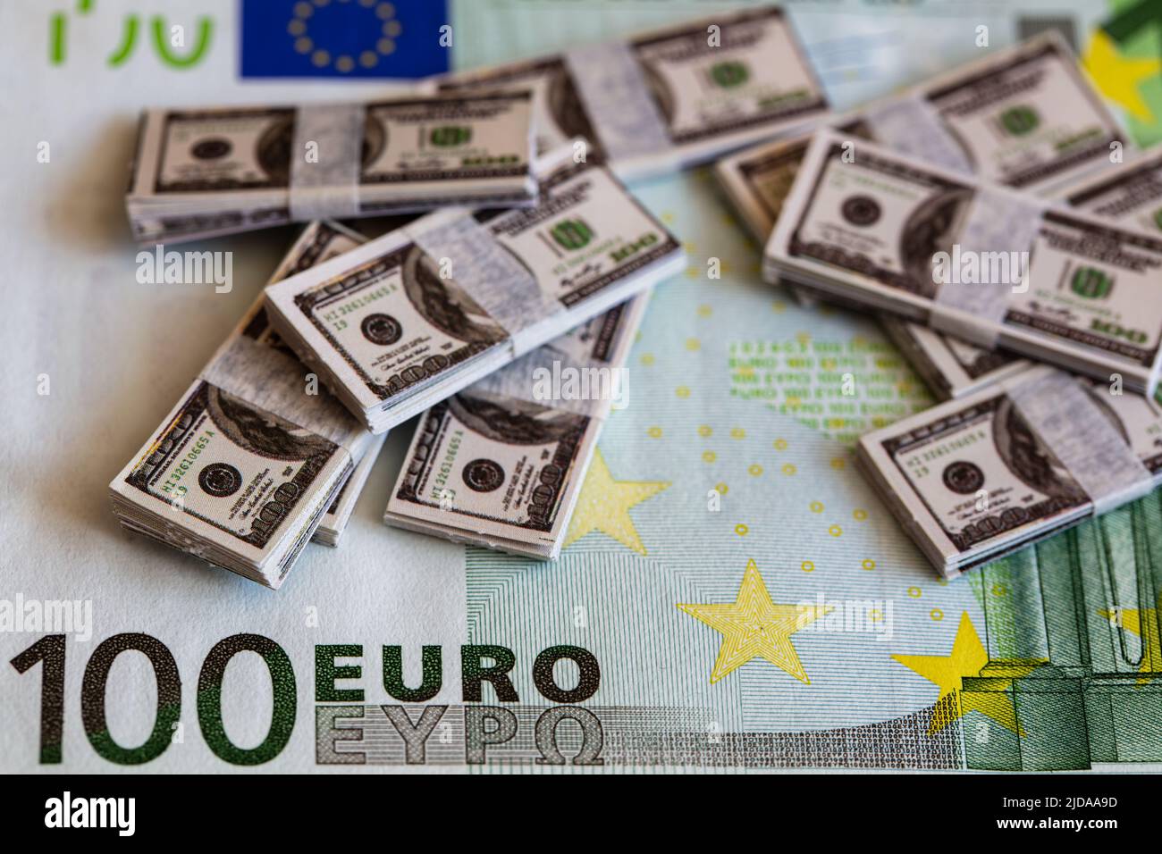 bundles of miniature 100 dollar banknotes on 100 euro banknote ...