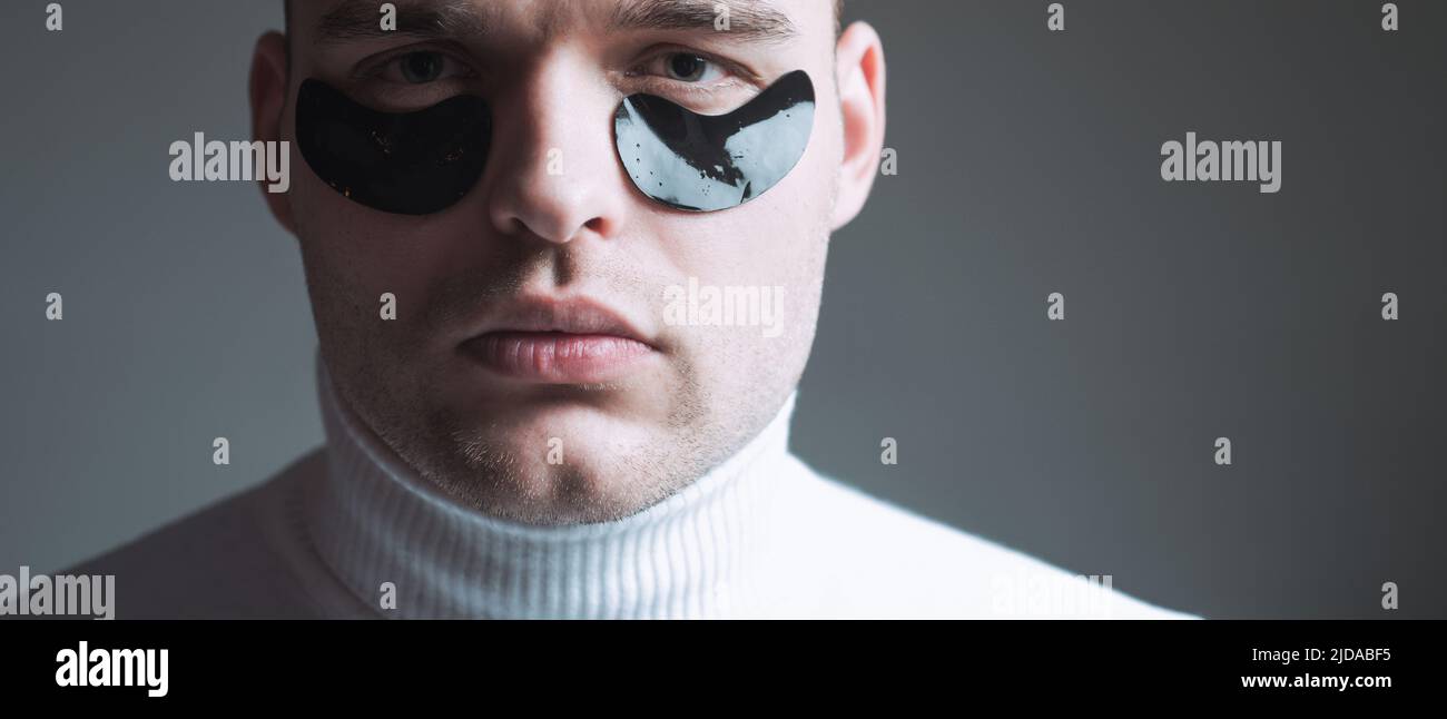 Man with black eye patches close up face. Beauty treatment. Skin care ...