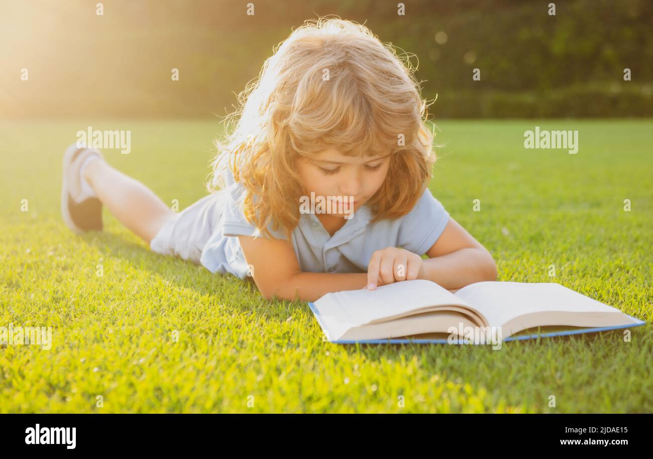 Smart clever Kids. Child relax in the holiday. Kid read books on grass ...
