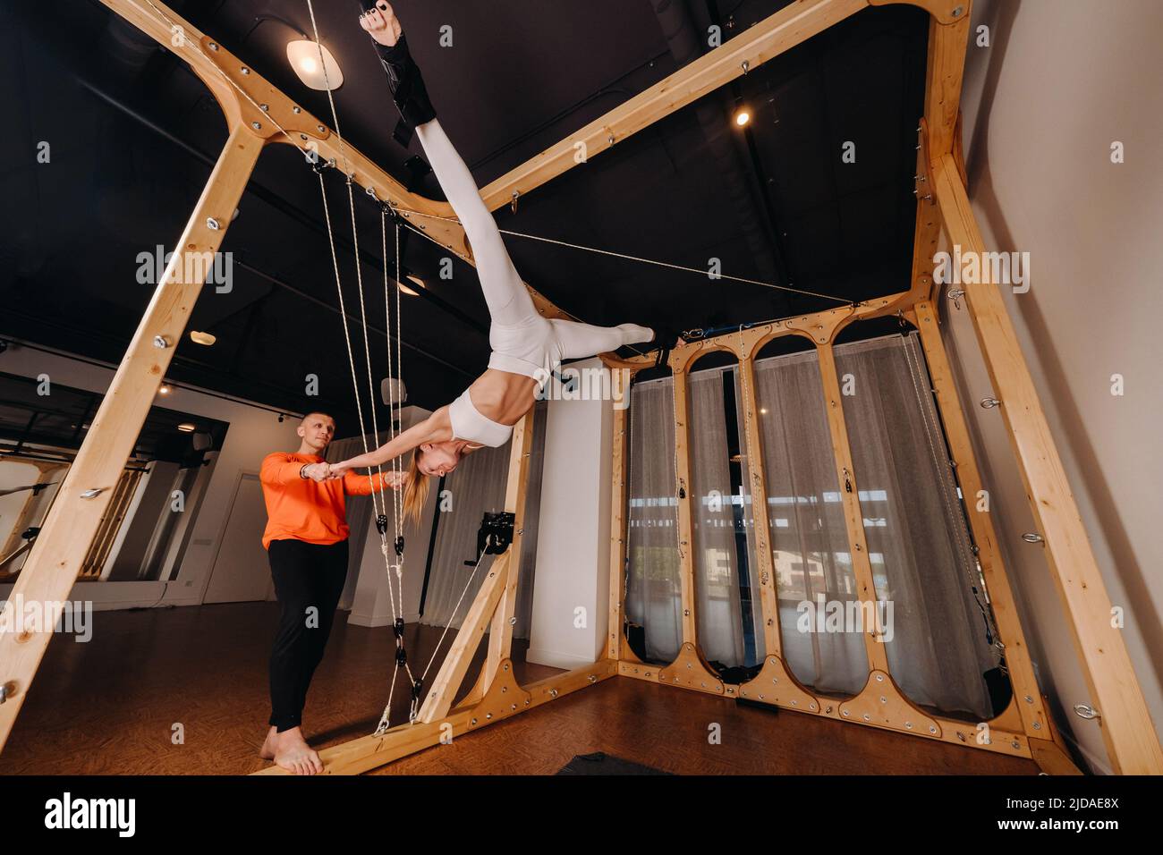 A trainer stretches a girl in a sports uniform on a simulator for ...