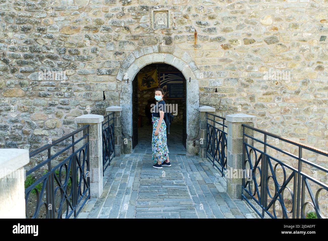 a masked tourist enters the fortress for a tour. Greece, kalabaka Stock ...