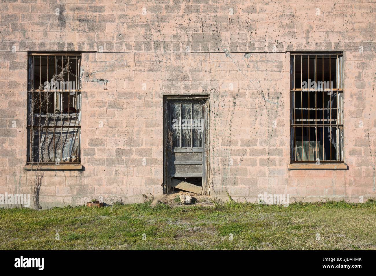 Abandoned jailhouse facade, an empty building with barsont the windows ...