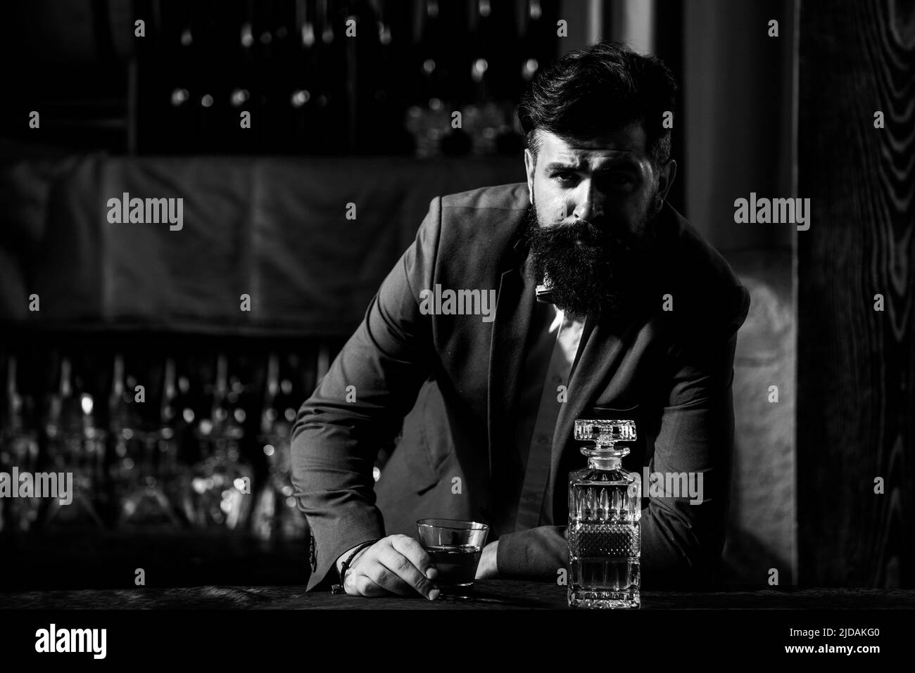 Barman luxury beverage concept. Man with beard holds glass with alcohol ...