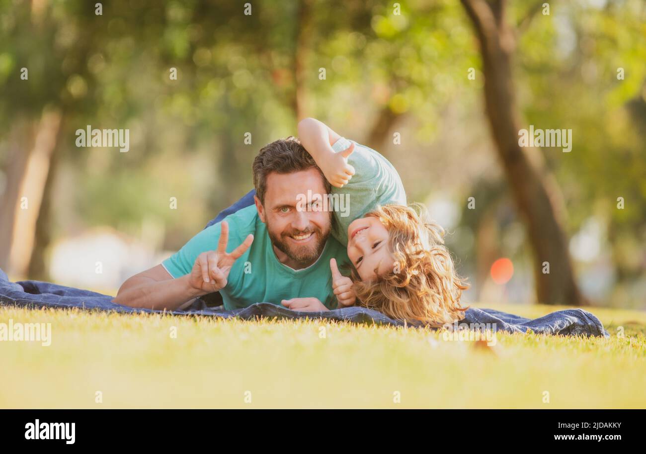 Father and son relaxing on nature in park. Happy dad and child enjoying ...