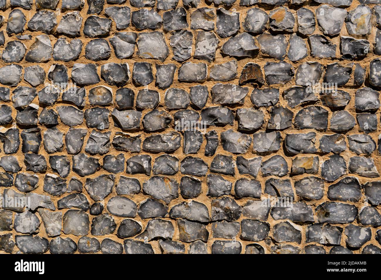 View of a big wall made of flint stones, building material in ...