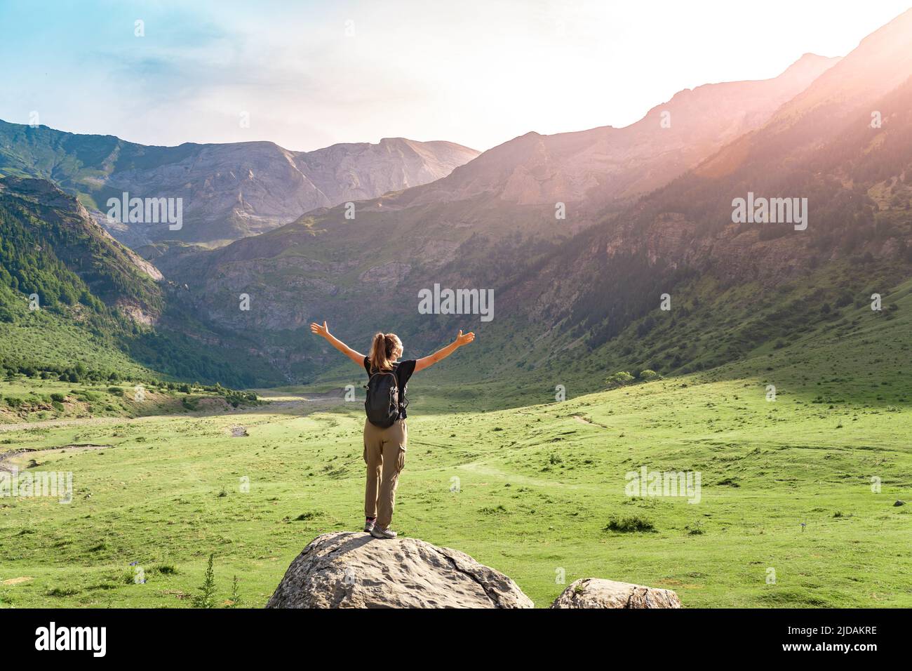 Female hiker in top of a rock with arms raised enjoying amazing ...