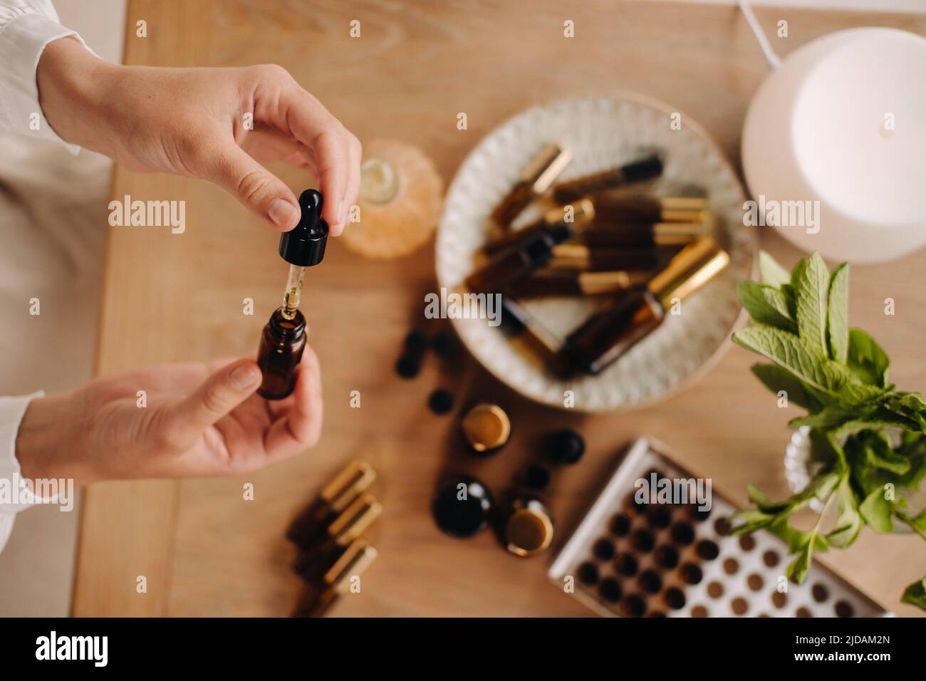 Close-up of female hands holding a bottle of essential oil ...
