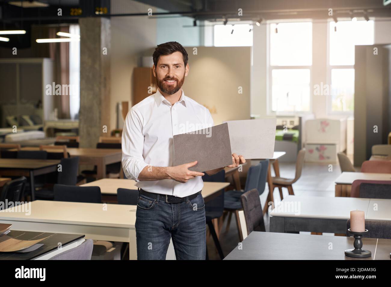 Front view of fashionable young male designing furniture indoors ...