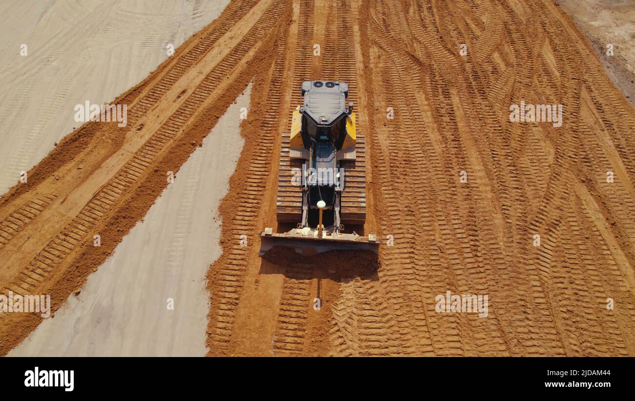 Horizontal aerial outdoor shot. Bulldozer during works at a road ...