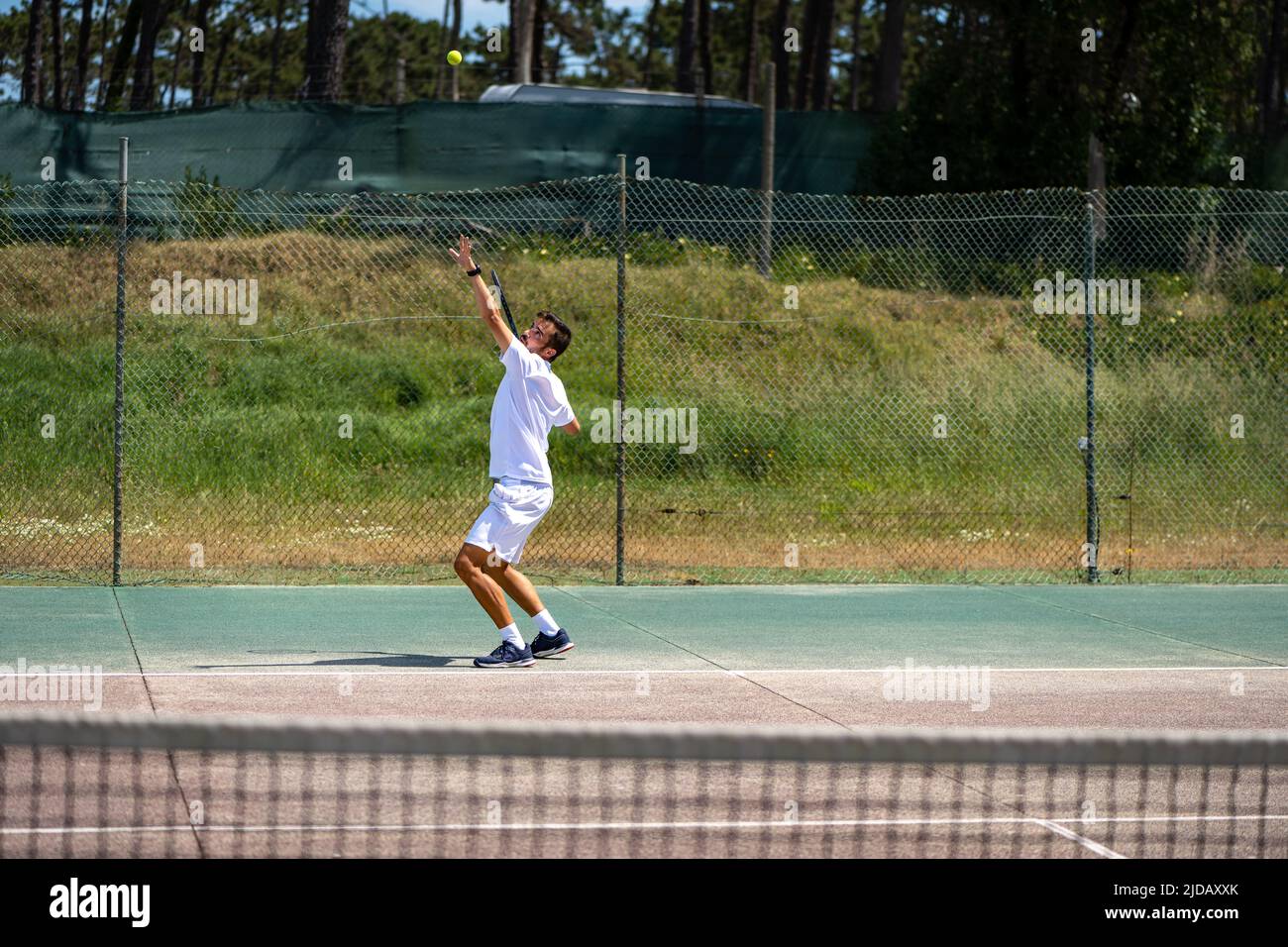 Tennis player performing a service on court Stock Photo - Alamy
