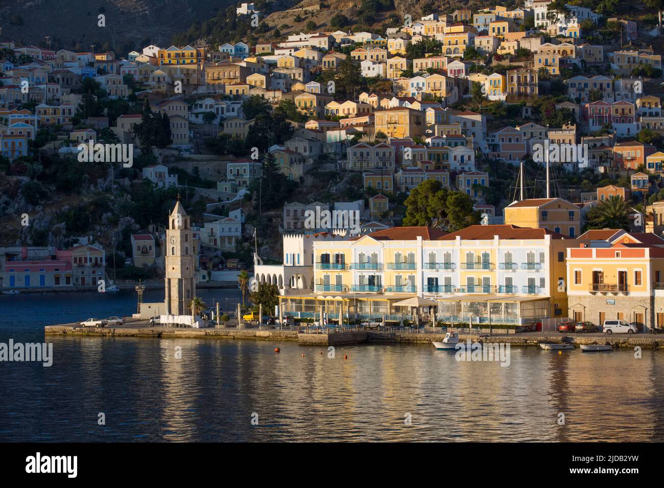 Symi Clock Tower and sunlit buildings on the waterfront at Gialos ...