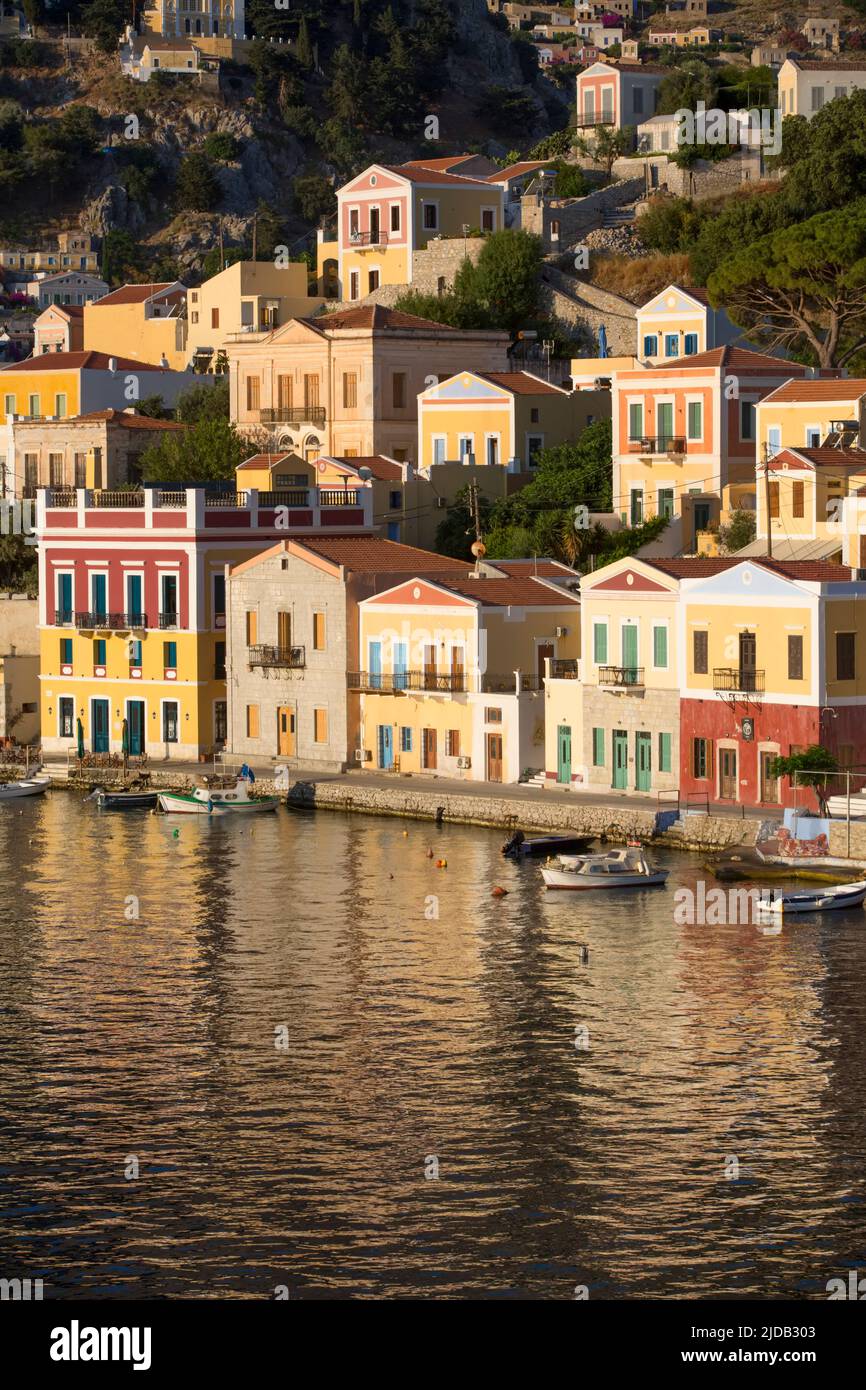 Warm sunlight on the colorful buildings along the waterfront in Gialos ...