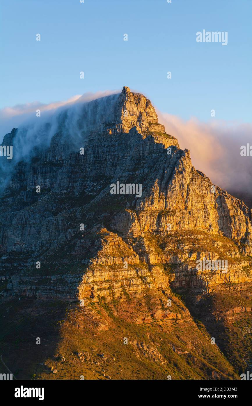 A view of sunlit Table Mountain from Lion's Head with a cloud formation ...