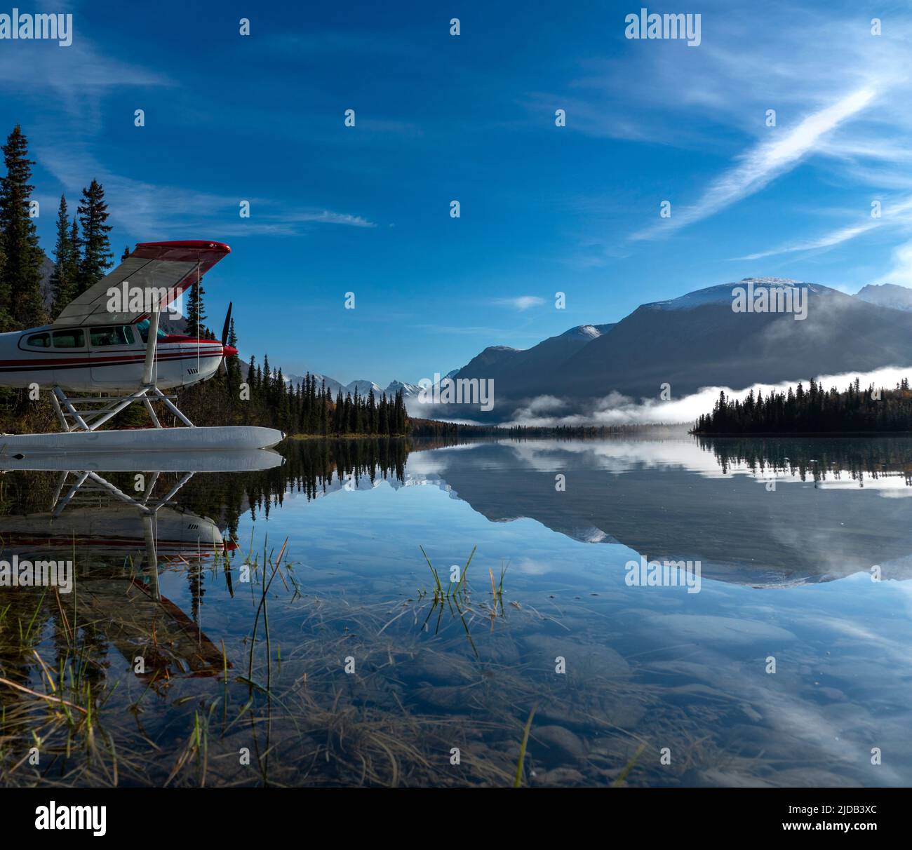 Silhouetted mountains reflected in the calm water of Kontrashibuna Lake ...
