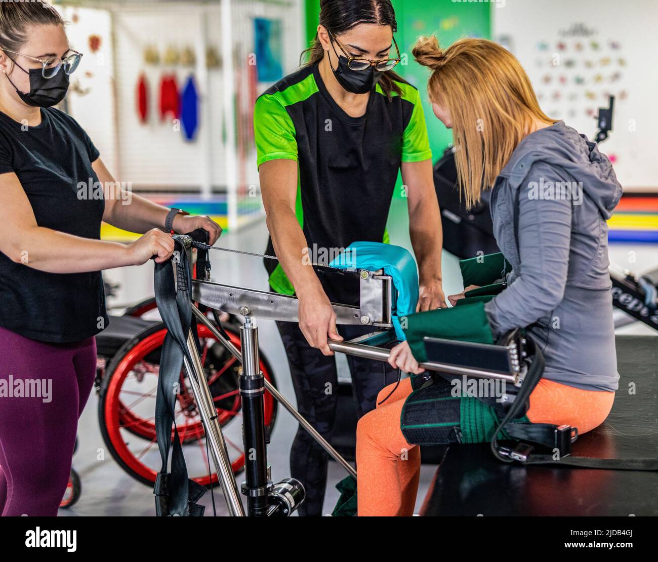 A paraplegic woman working out using an assisted walking machine with ...