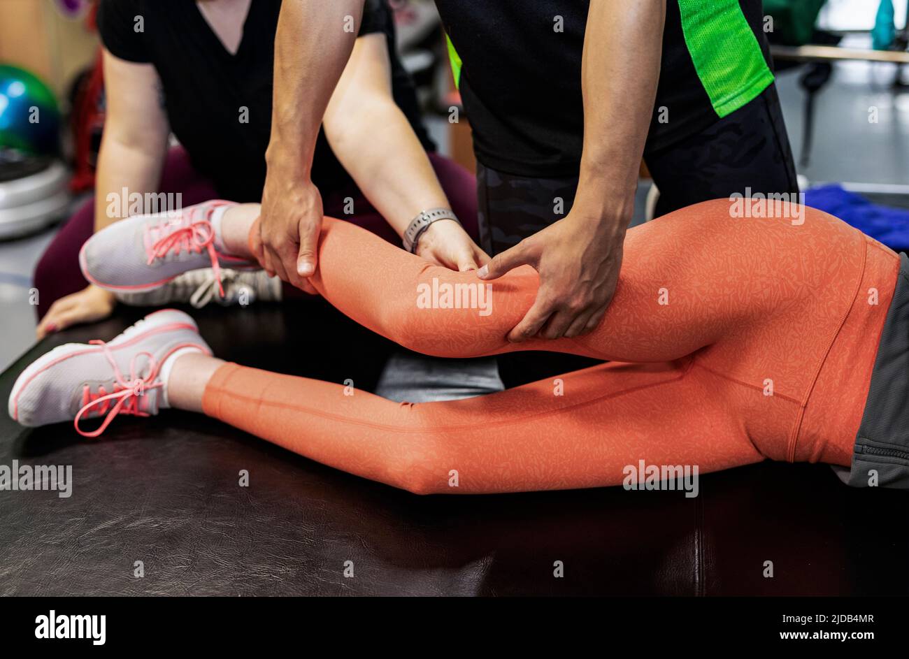 A paraplegic woman working on hip flexion while her trainer does ...