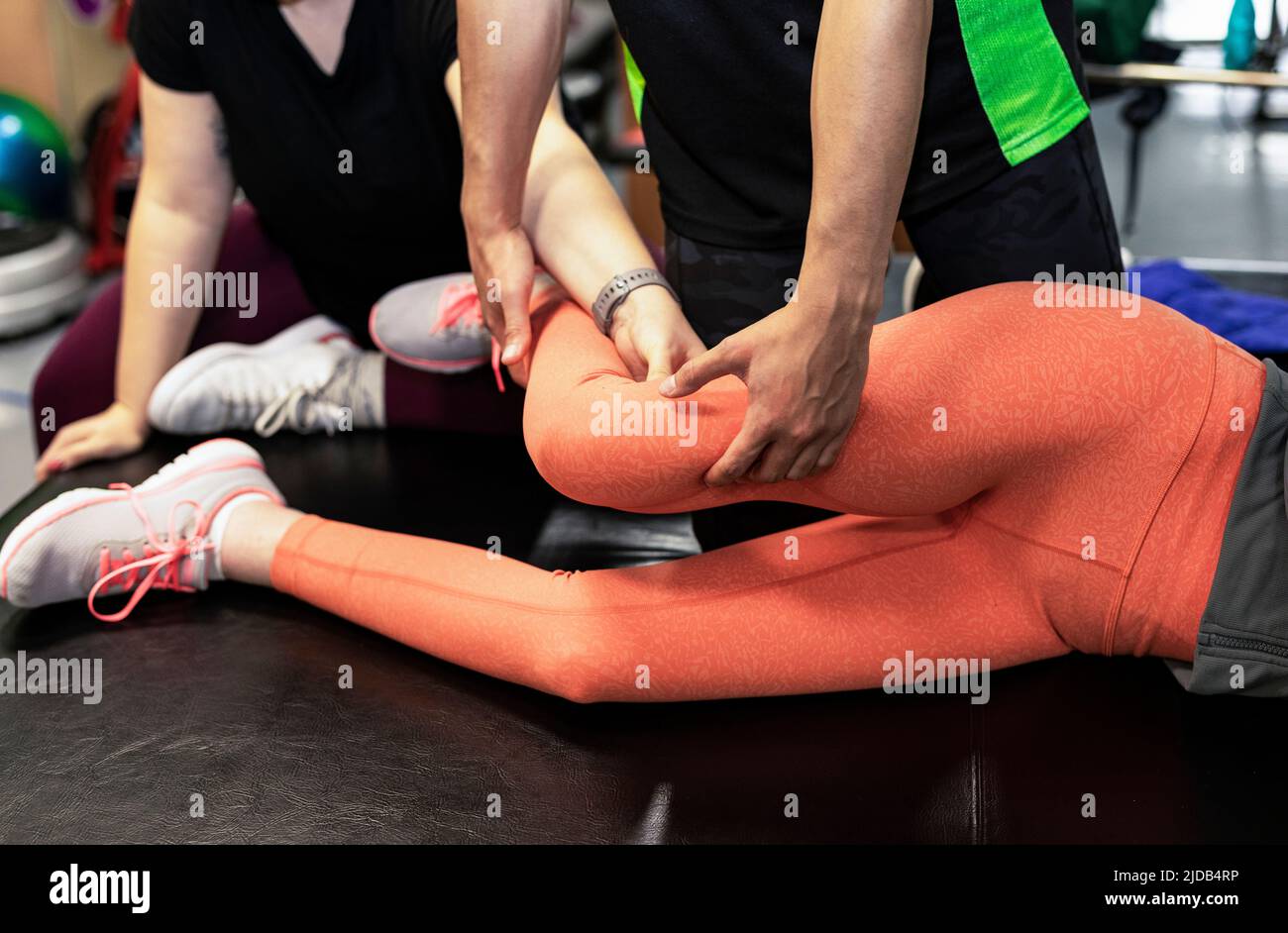 A paraplegic woman working on hip flexion while her trainer does ...