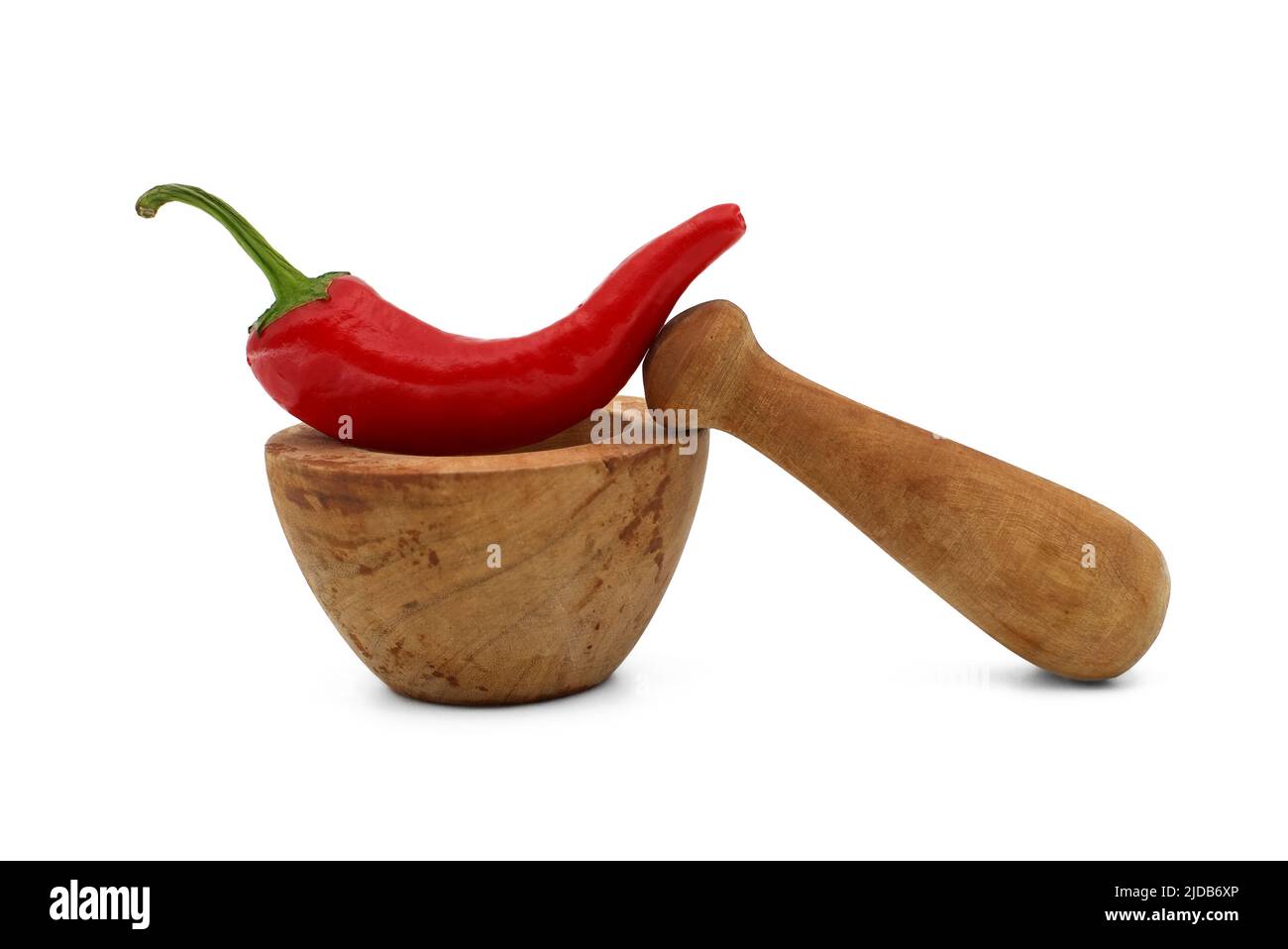 Old rustic wooden pestle and mortar alongside an fresh red chili pepper ...