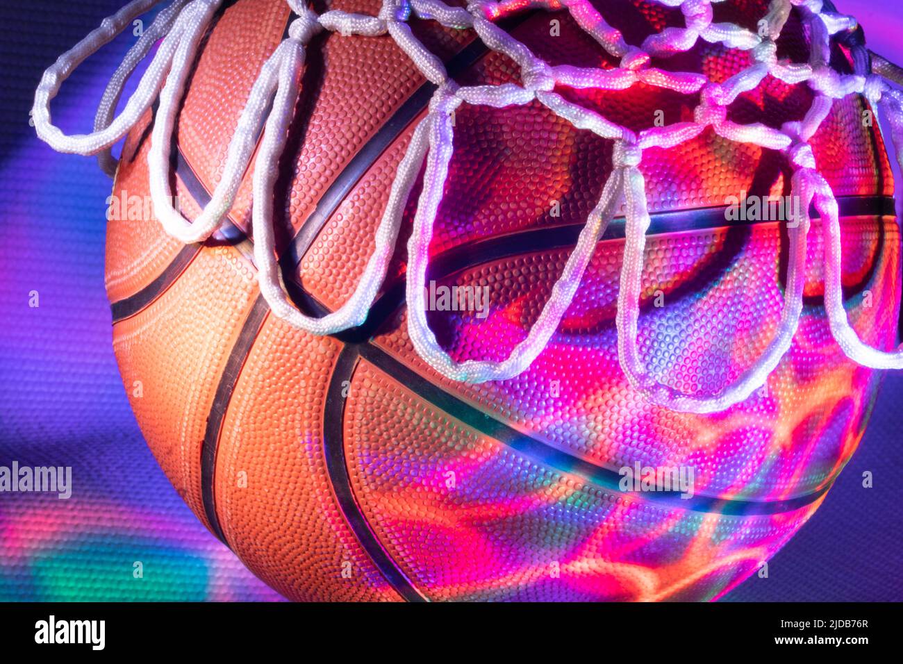 Basketball in net with colorful lights Stock Photo - Alamy